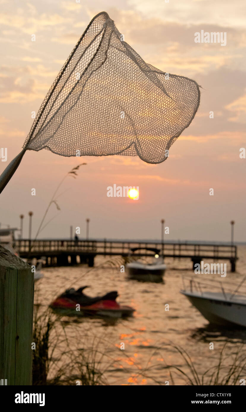 Fishing net by pier at sunset Stock Photo - Alamy
