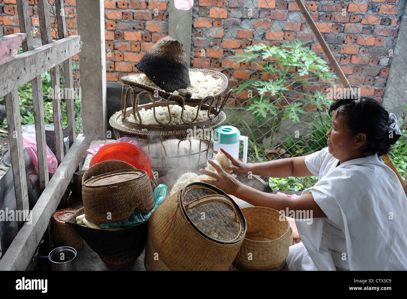 Buddhist nun cooking sticky rice in Luang Prabang, Laos Stock Photo - Alamy