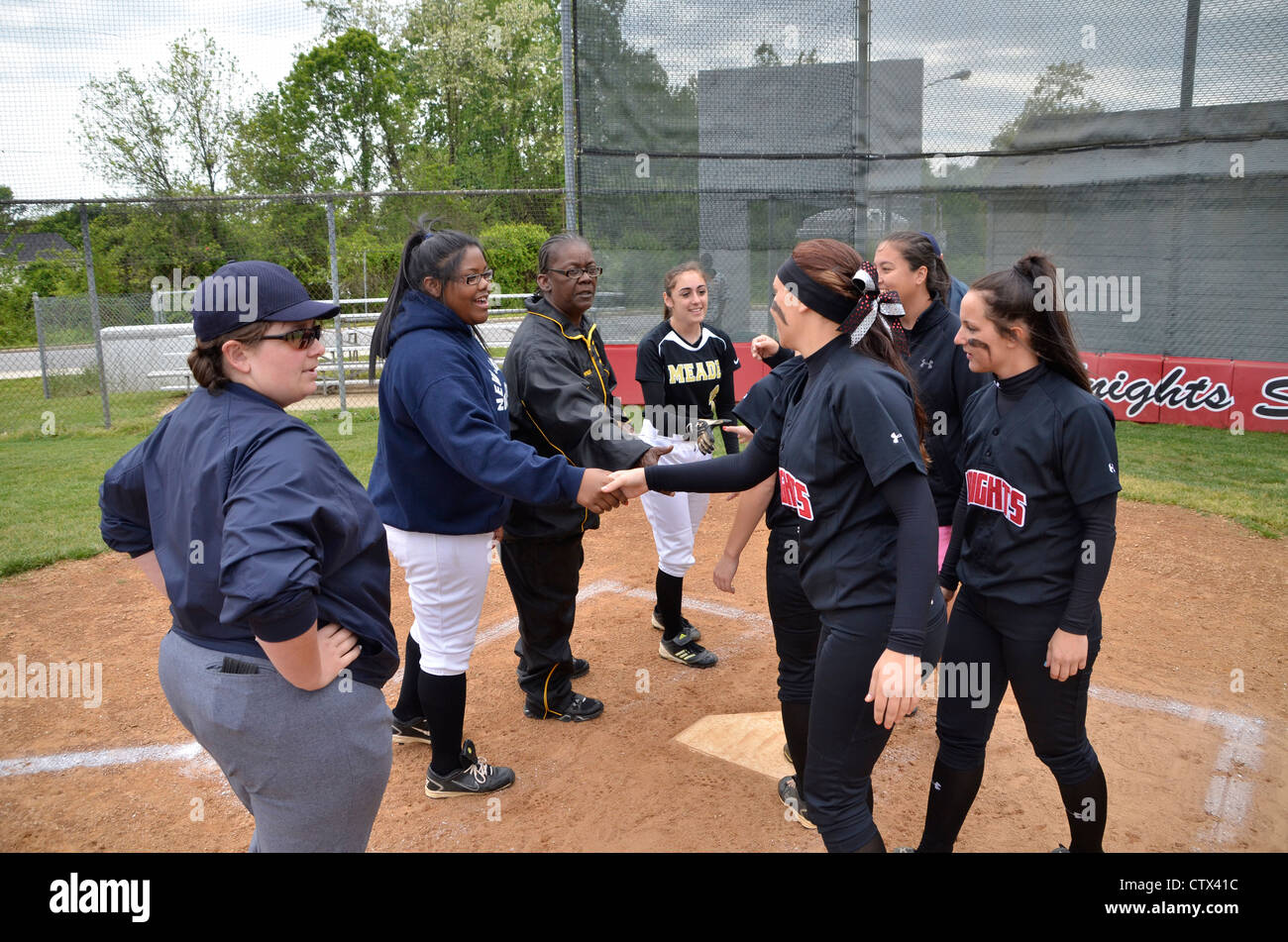 coaches and players shake hands while an umpire looks on before the ...