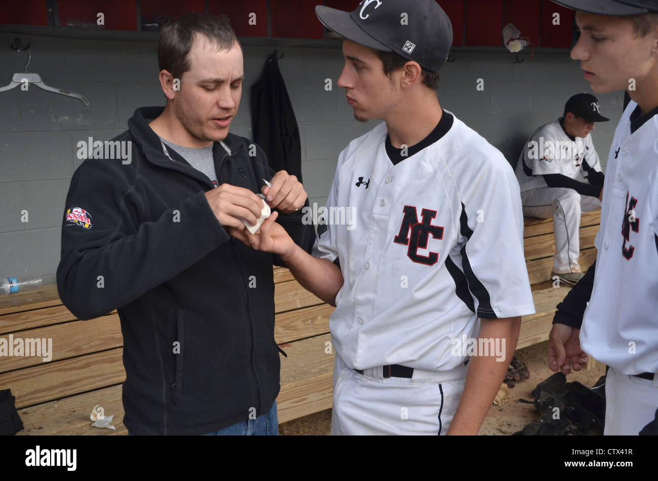 medic treats an injured teen baseball player who cut his finger in a ...