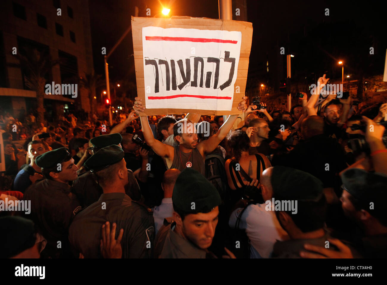 A demonstrator holds up a paperboard sign which reads "Wake up" during ...