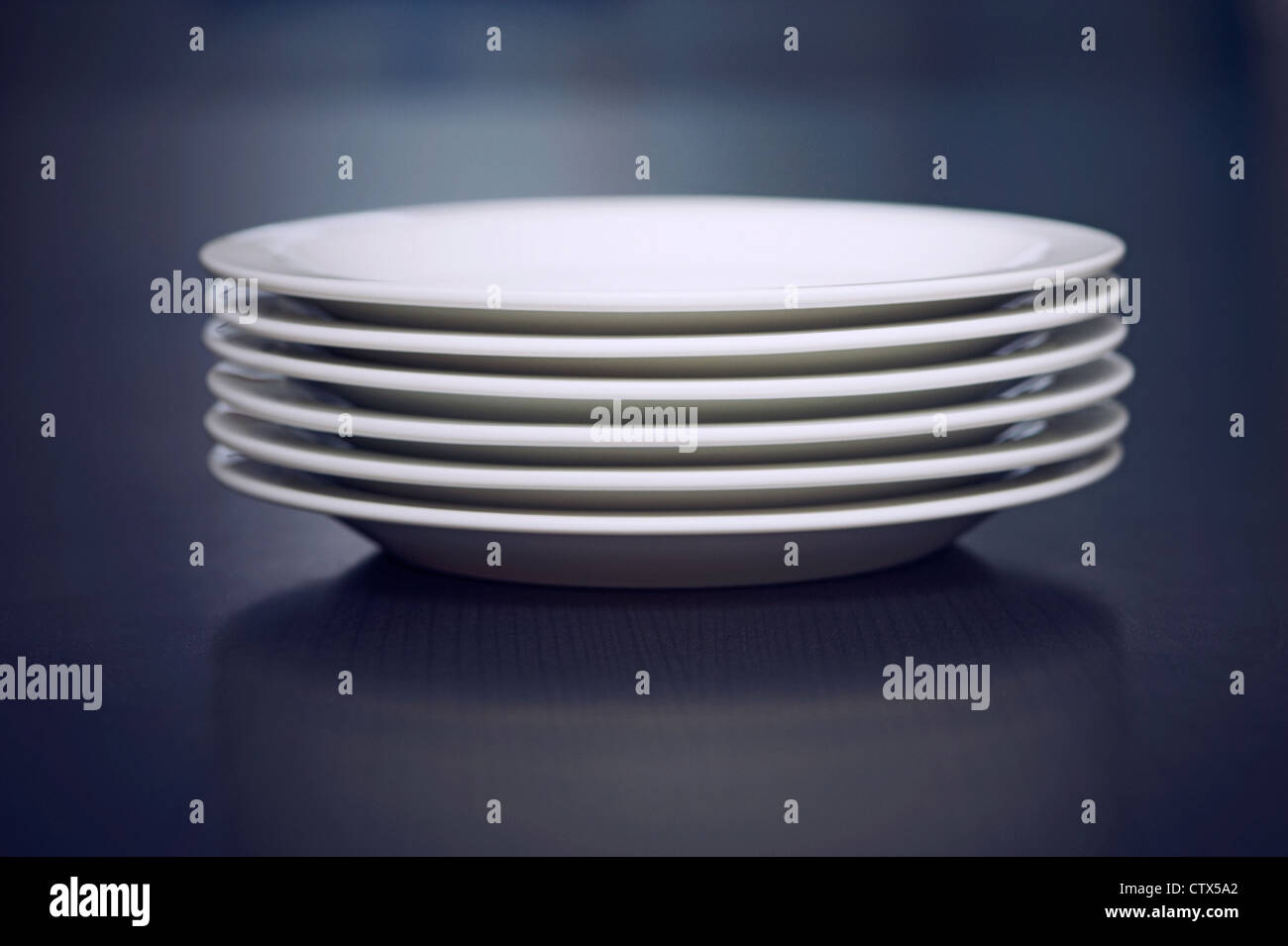 A stack of white plates on a table Stock Photo - Alamy