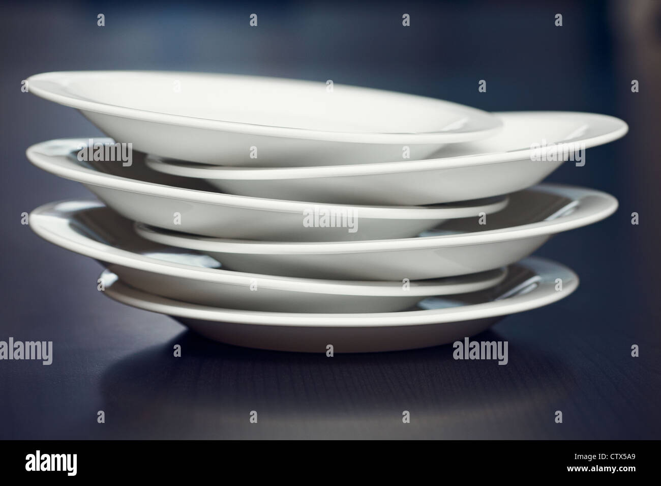 A stack of white plates on a table Stock Photo - Alamy