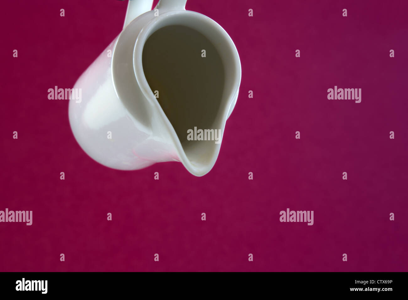 White pot for some liquid on pink background Stock Photo - Alamy