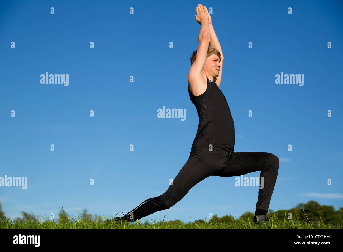 Sportsman trying stretch left leg and both hands Stock Photo - Alamy