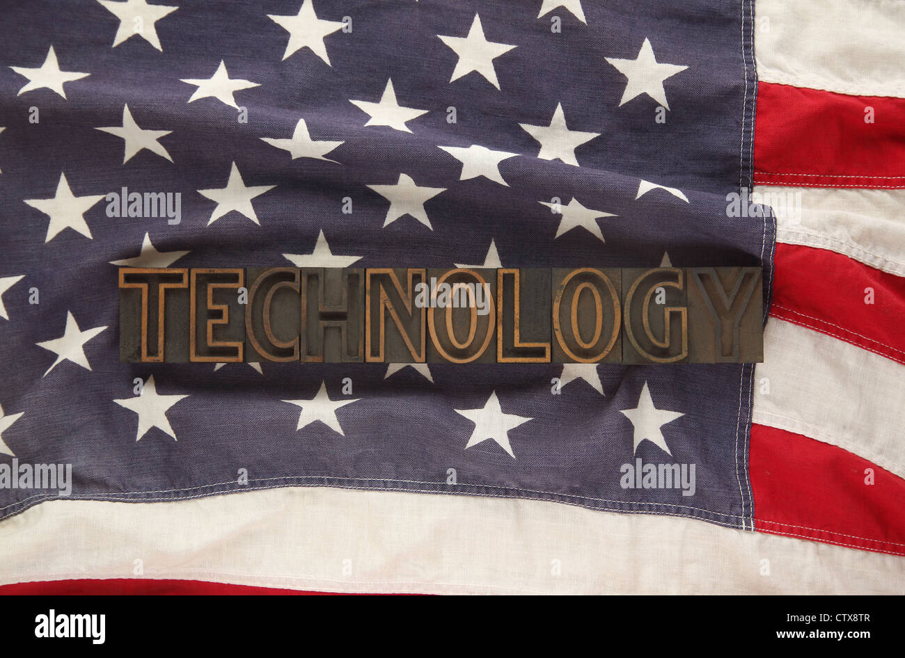 the word technology in letterpress wood type on an old American flag ...