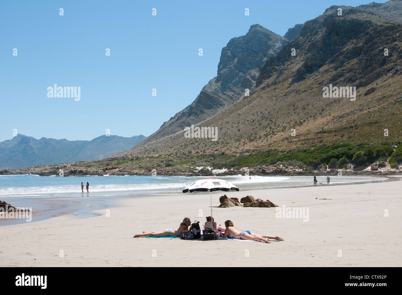 Holidaymakers sunbathing on the beach at Rooi Els on the Cape Whale ...