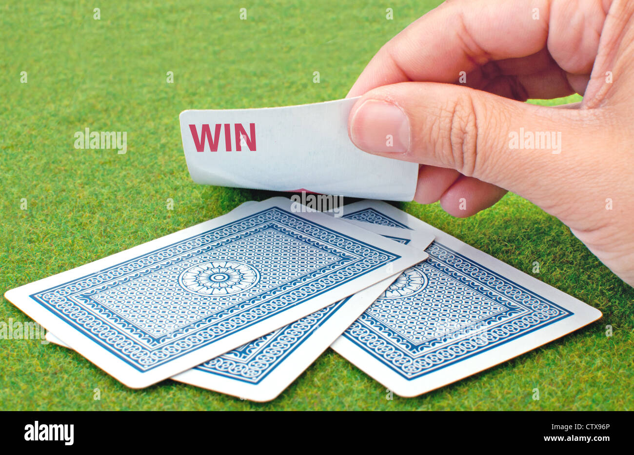 Playing card reveals the word win Stock Photo - Alamy