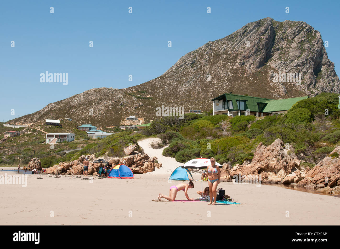Holidaymakers sunbathing on the beach at Rooi Els on the Cape Whale ...