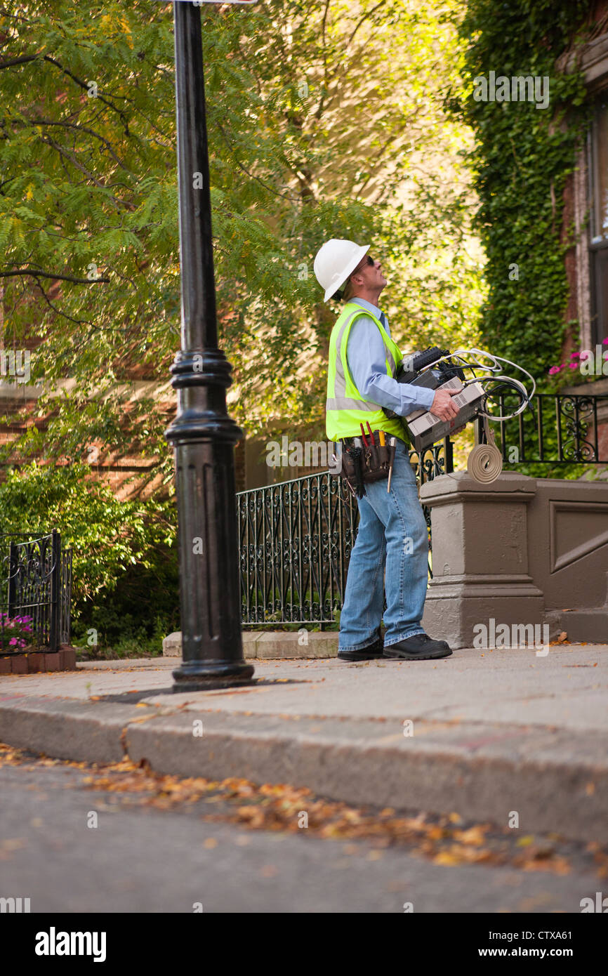 Cable installer bringing equipment to city building in the fall Stock ...