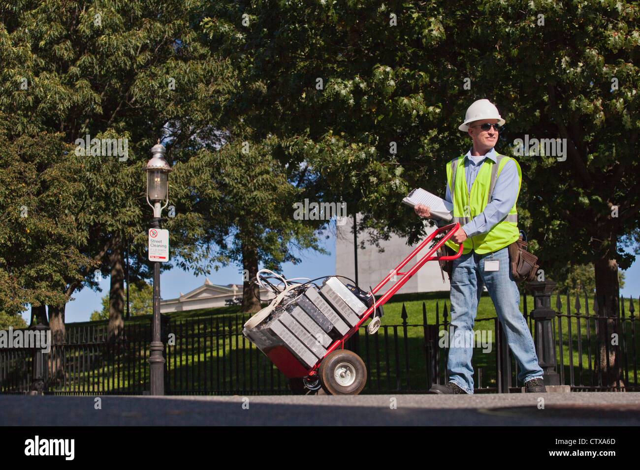 Cable installer with hand truck full of set-top boxes on sidewalk Stock ...