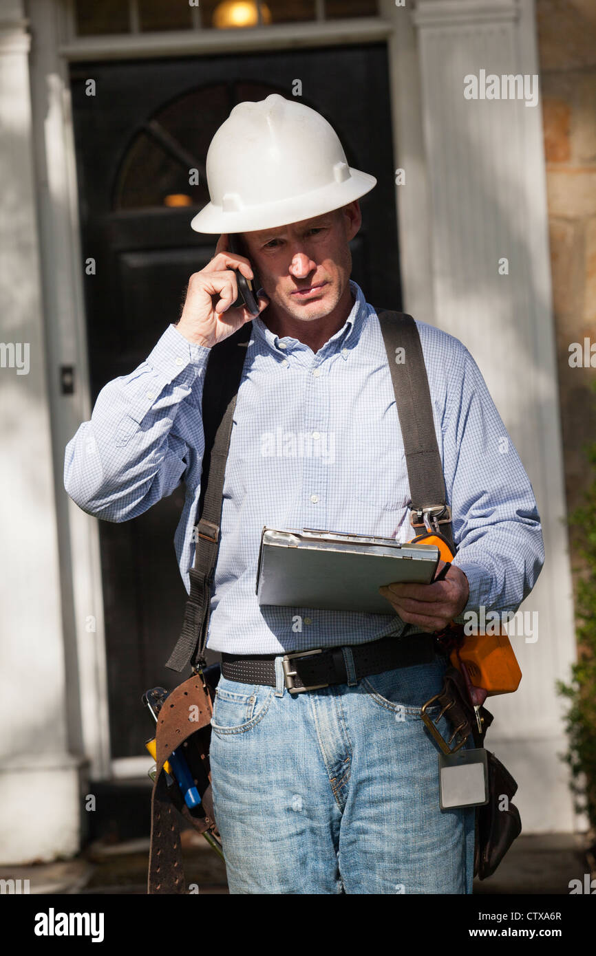 Cable installer leaving home after completing work order and talking on ...