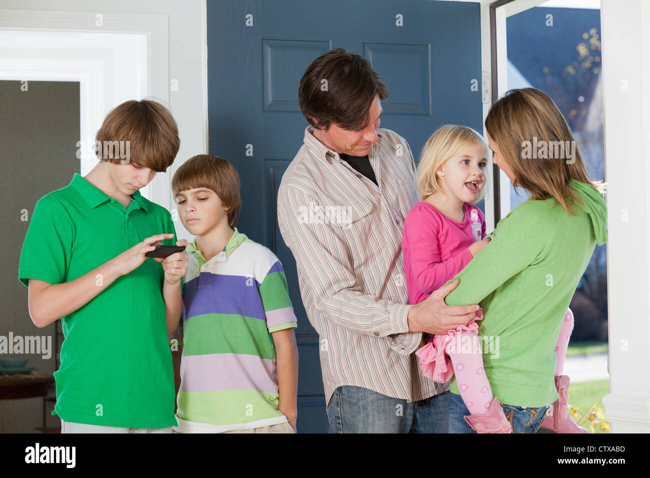 Family at the front door of home Stock Photo - Alamy