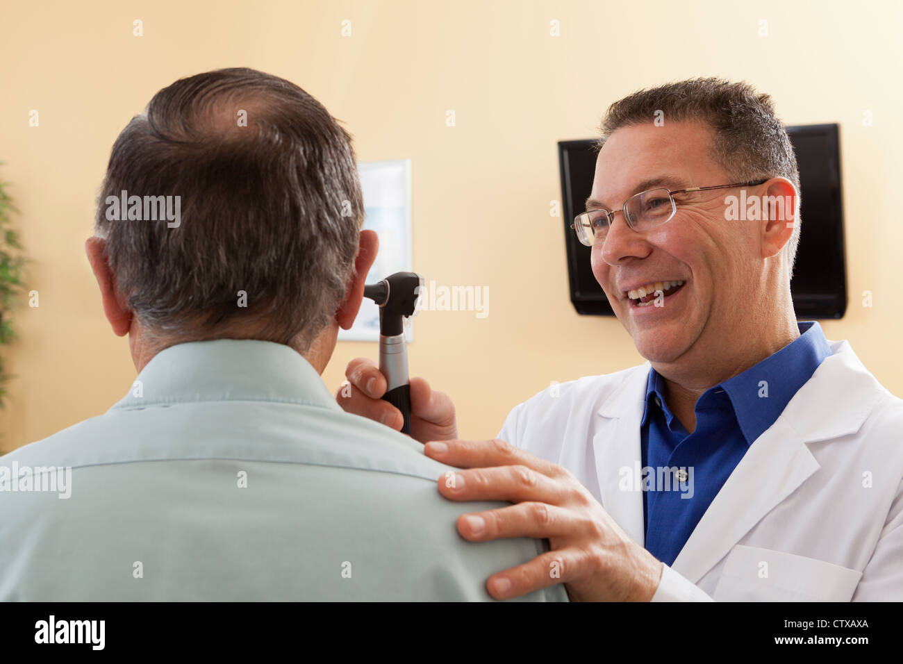 Audiologist doing an ear canal inspection of a patient Stock Photo - Alamy