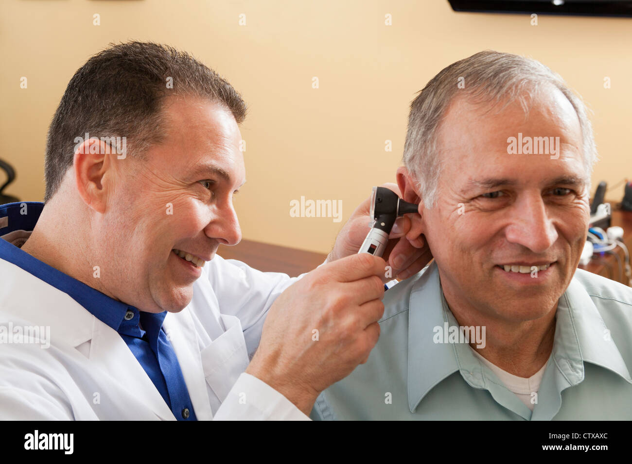 Audiologist doing an ear canal inspection of a patient Stock Photo - Alamy