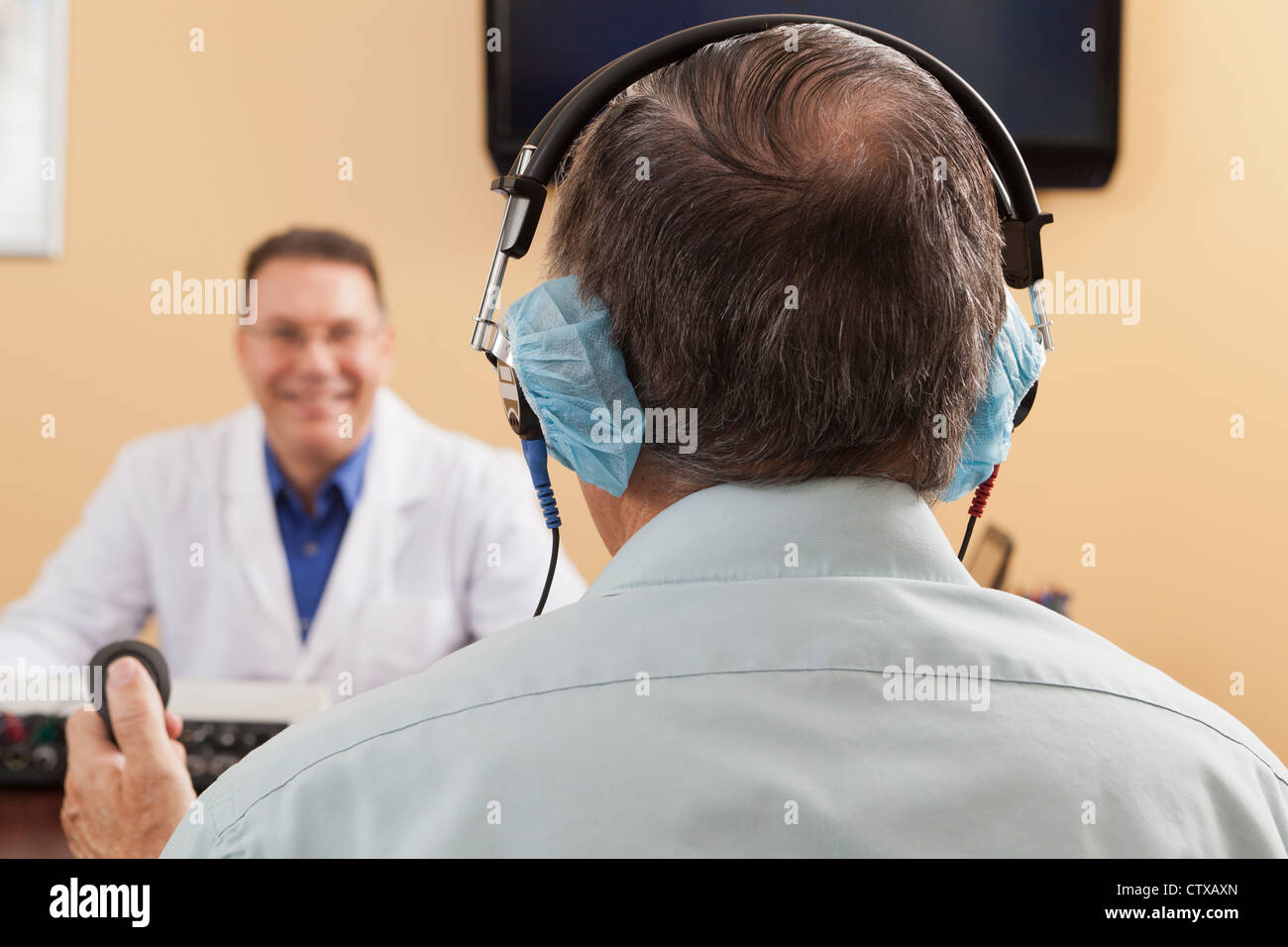Patient using response button during audiometric evaluation Stock Photo ...