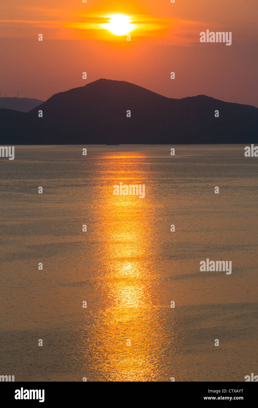 Evening summer coastline with pink-yellow sunset, sun track and Island ...