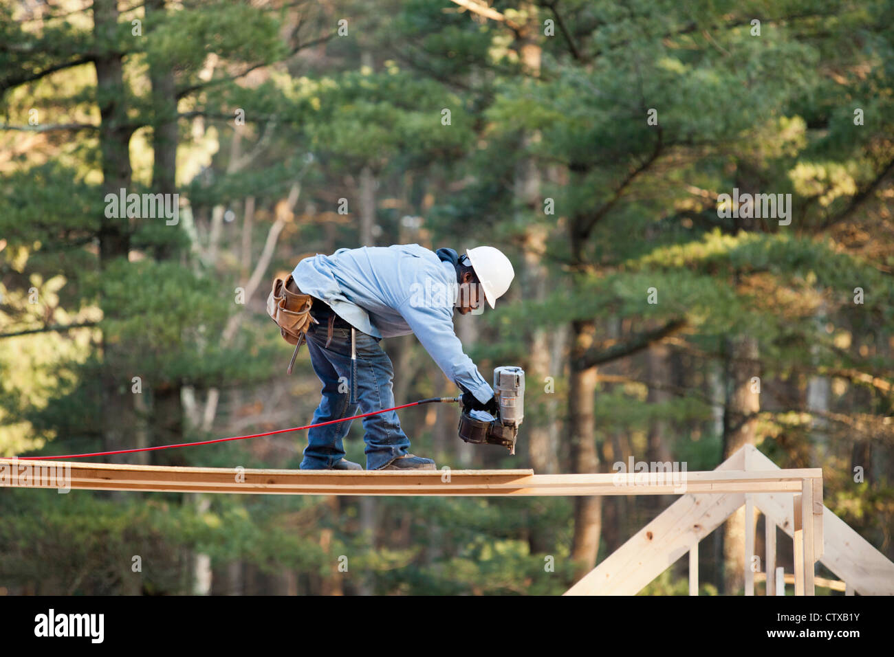 Carpenter using a nail gun on a temporary platform Stock Photo - Alamy