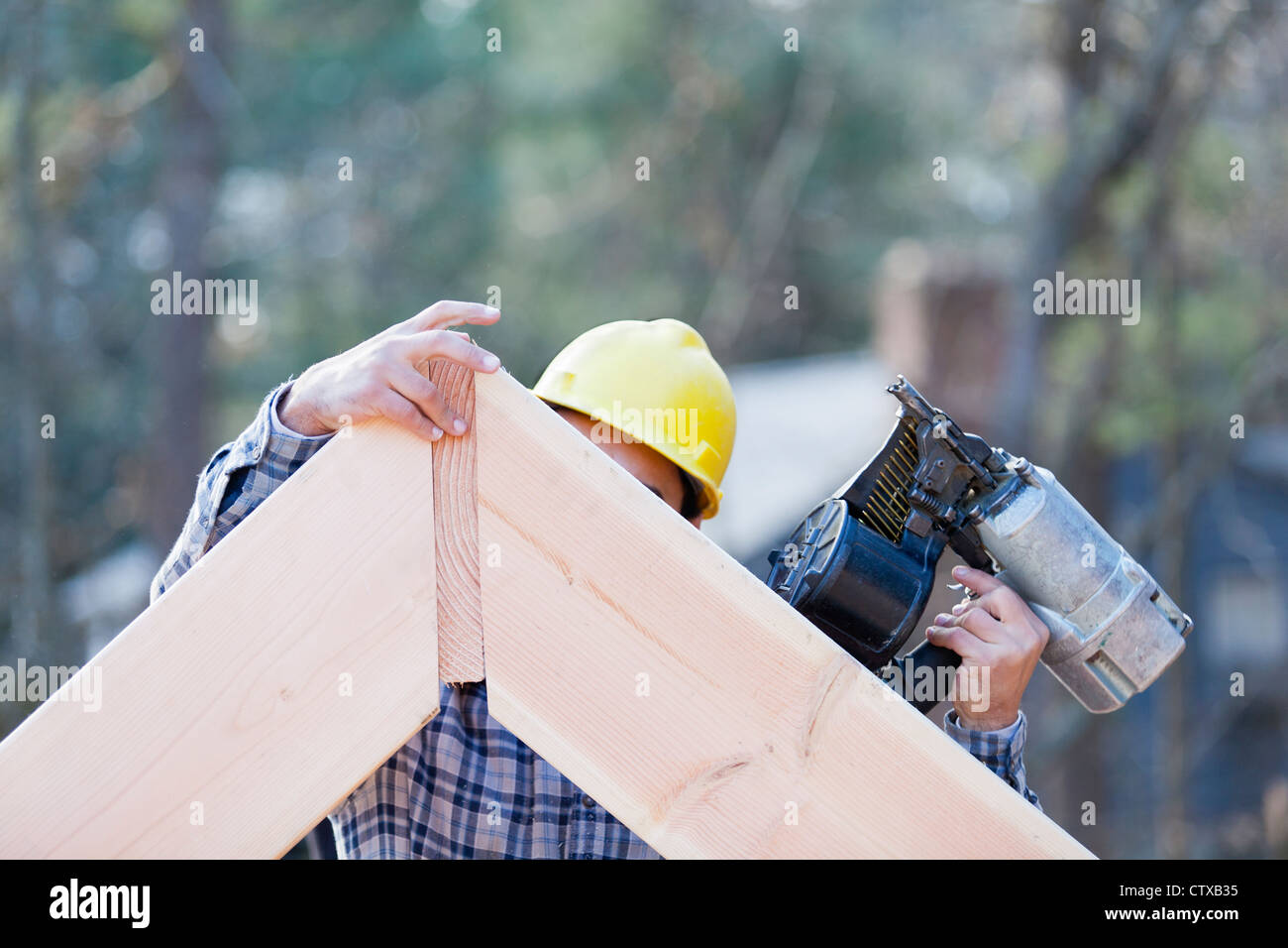 Carpenter nailing a rafter at peak Stock Photo - Alamy