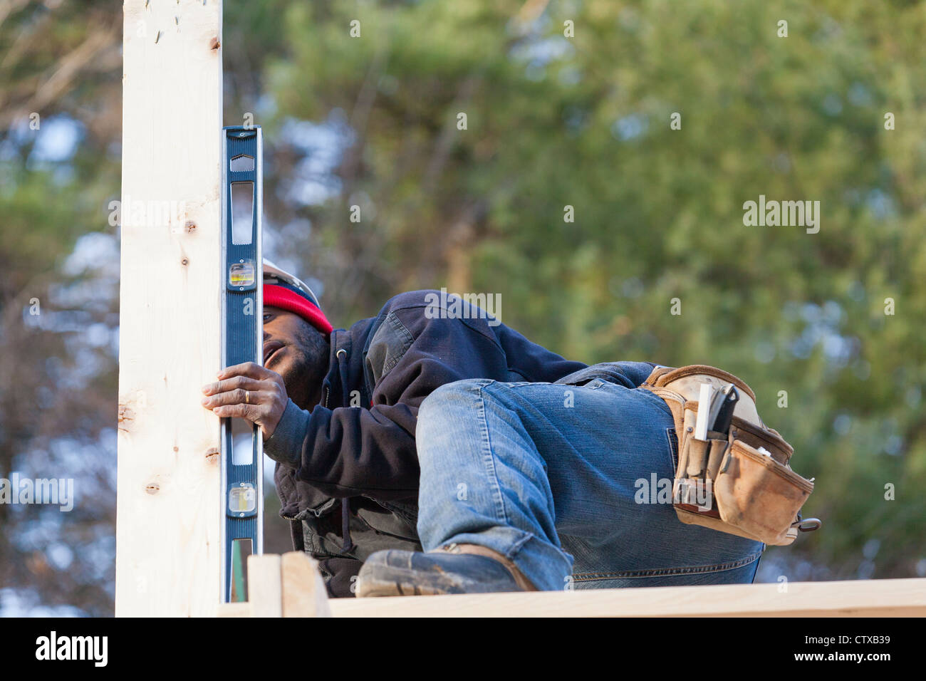 Carpenter using a level to measure vertical roof support Stock Photo ...