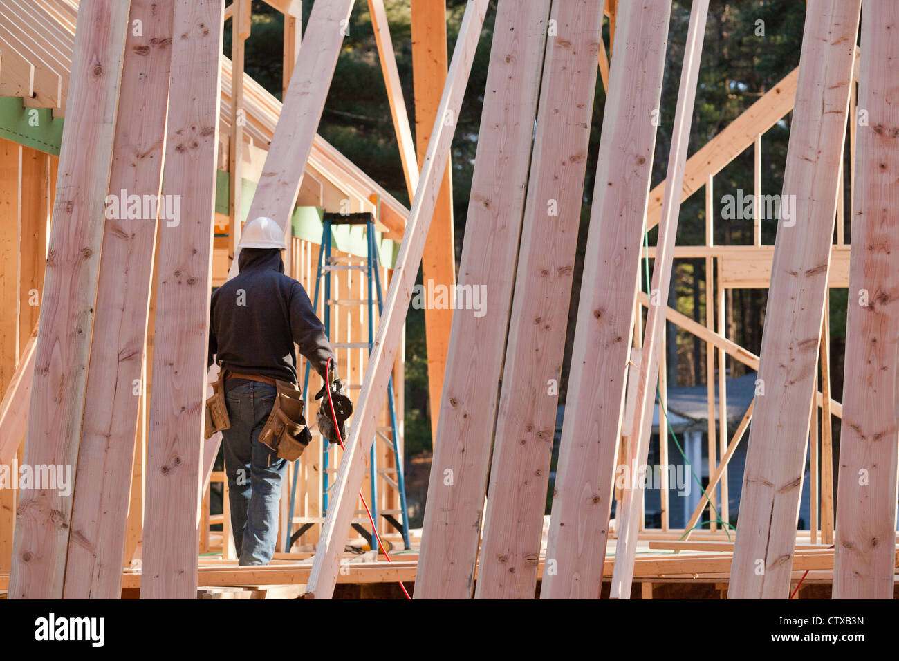 Carpenter with a nail gun at a house under construction Stock Photo - Alamy