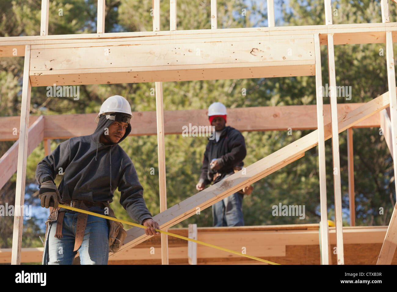 Carpenter measuring width of picture window frame Stock Photo - Alamy