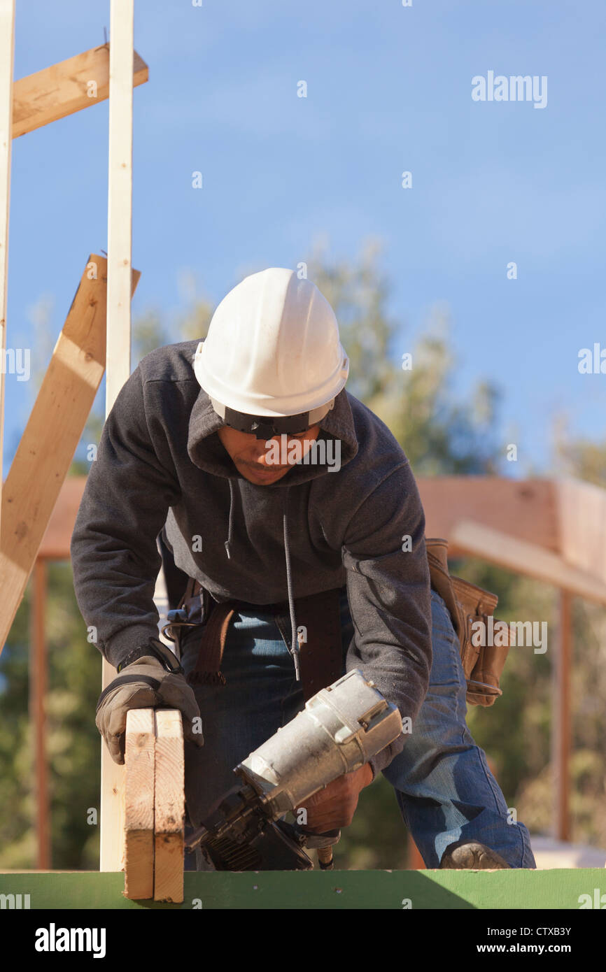 Carpenter nailing a rafter into place Stock Photo - Alamy