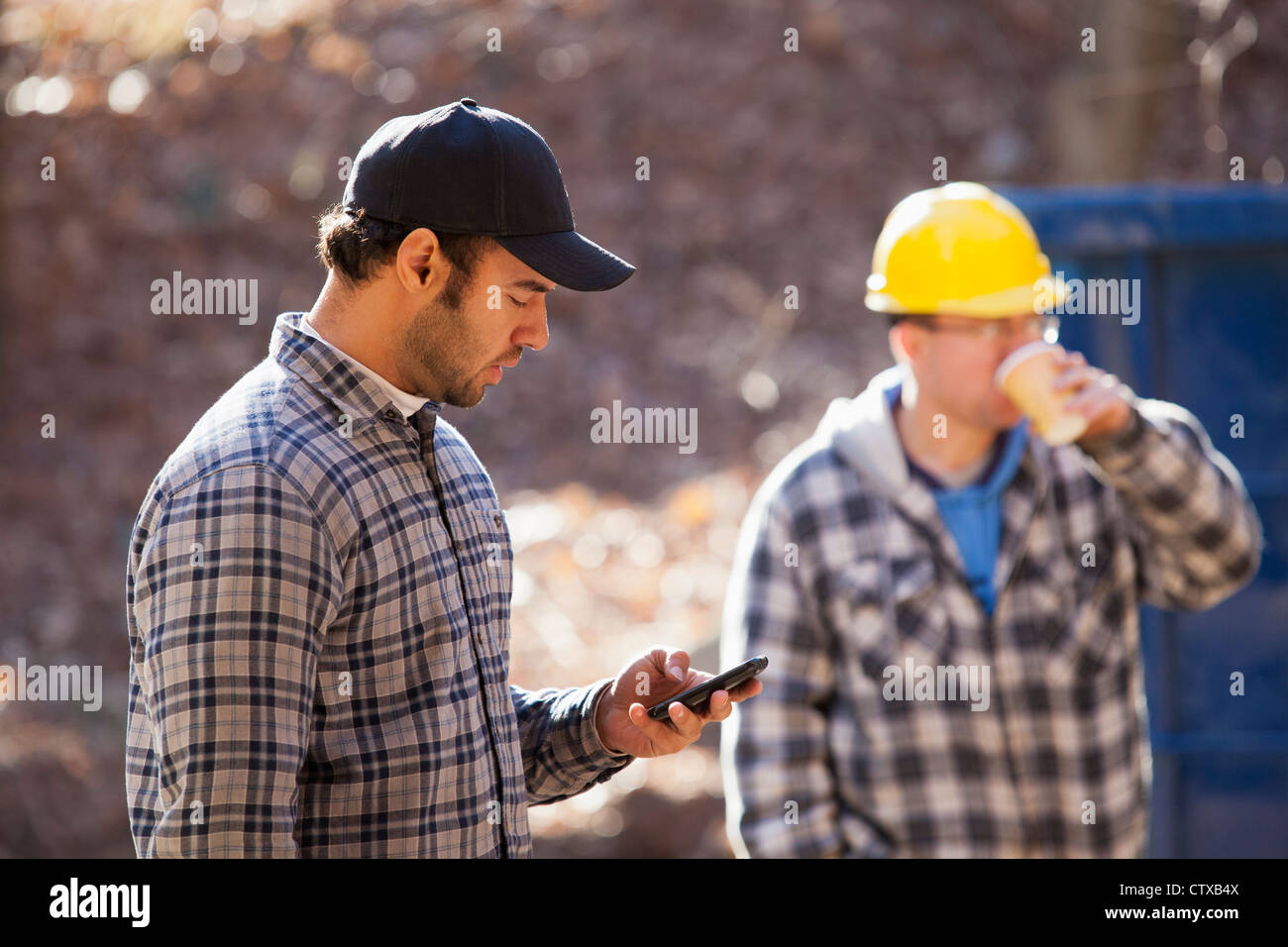 Carpenter using a mobile phone at construction site Stock Photo - Alamy