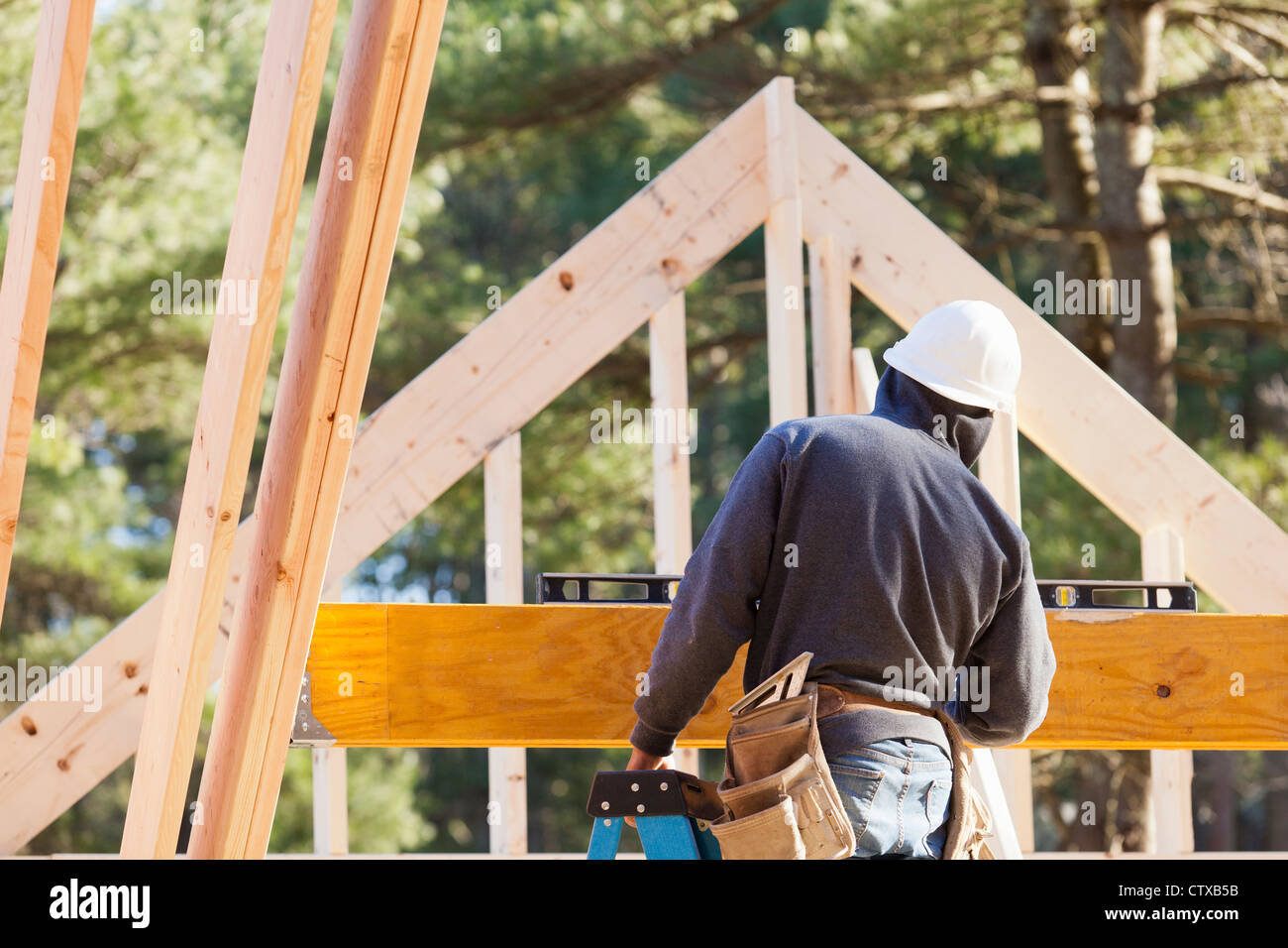 Carpenter using horizontal level on beam Stock Photo - Alamy