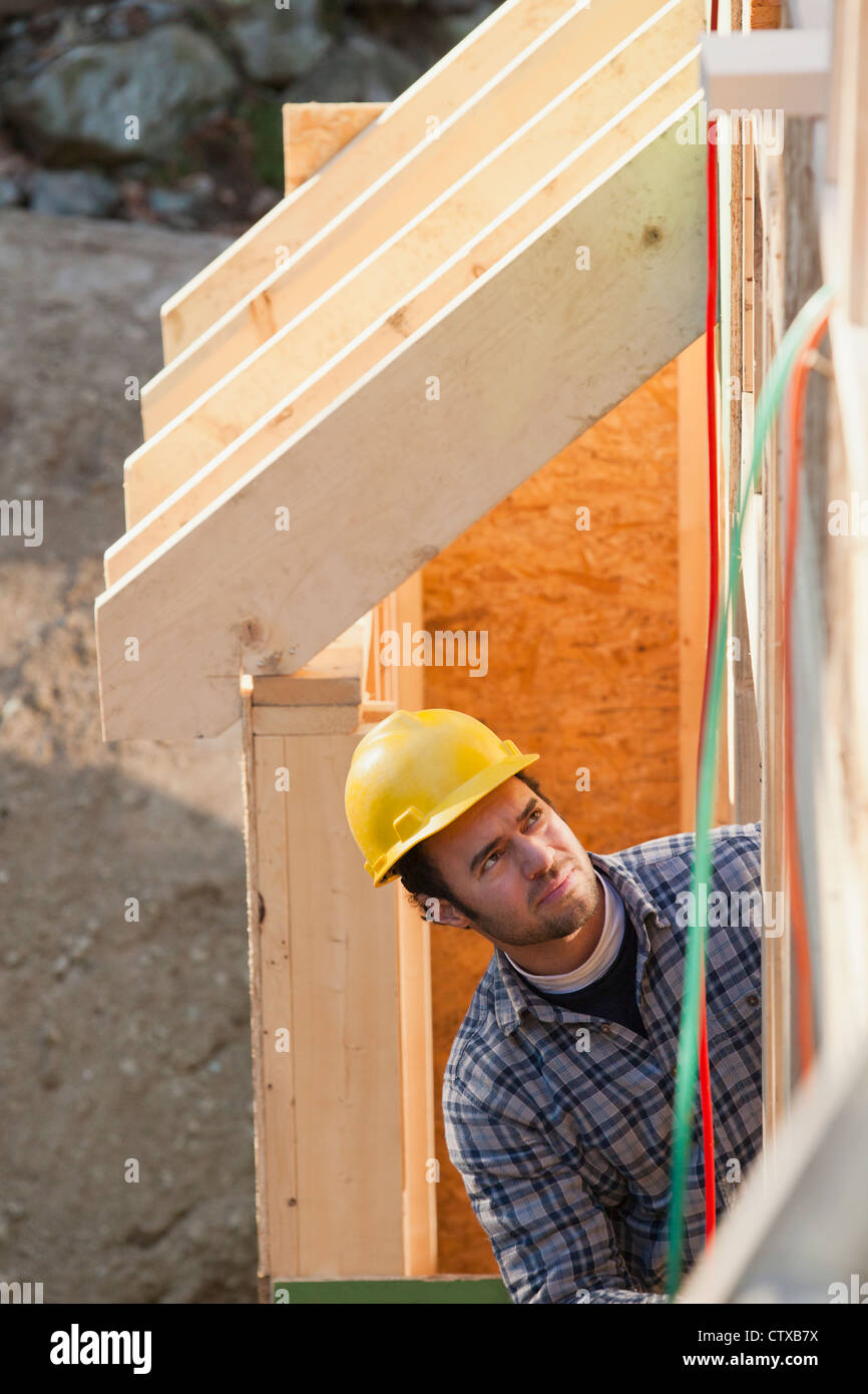 Carpenter reviewing exterior framing of a house Stock Photo - Alamy