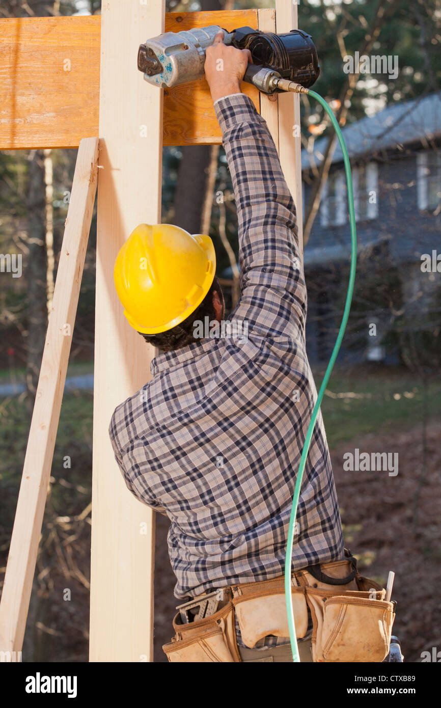 Carpenter using a nail gun on beam Stock Photo - Alamy