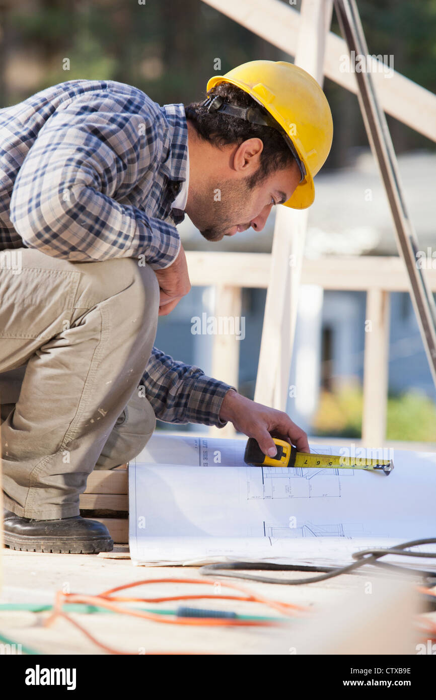 Carpenter measuring on house plan Stock Photo - Alamy