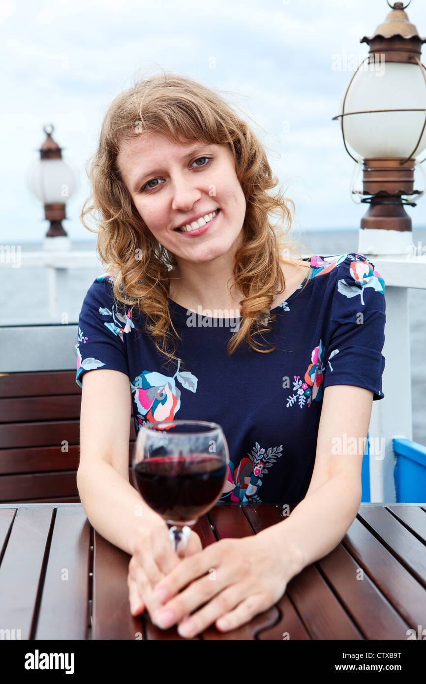 Pretty woman in dress with wine glass sitting at the table Stock Photo ...