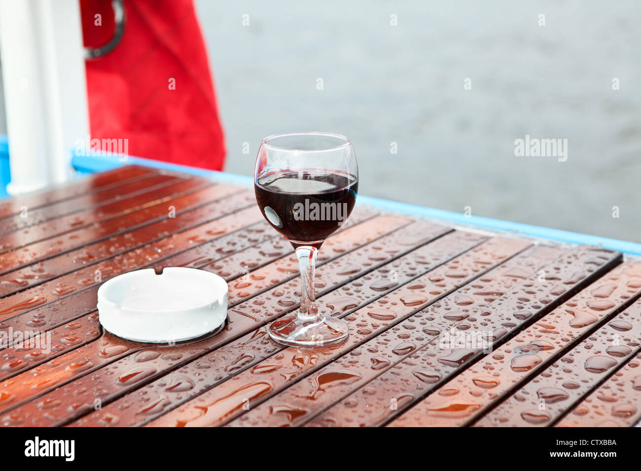 Glass of red wine on the table surface with rain drops Stock Photo - Alamy