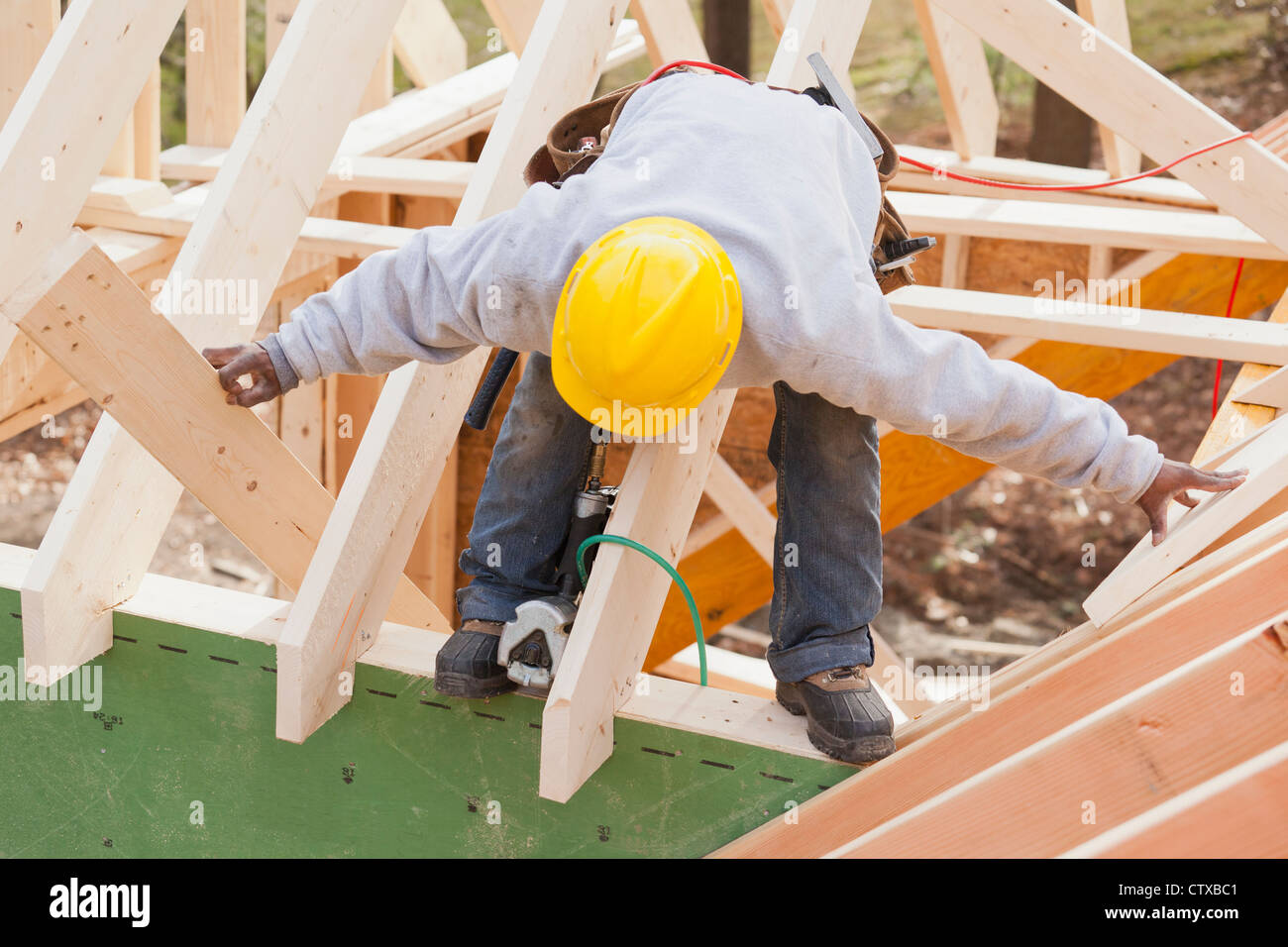 Carpenter lifting rafter for dormer Stock Photo - Alamy