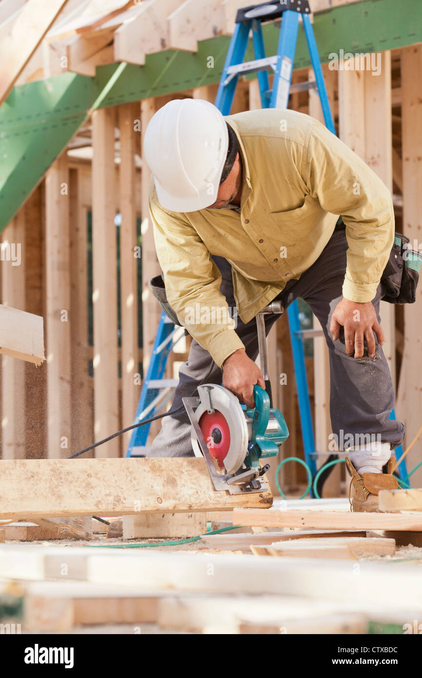 Carpenter using a circular saw on studs Stock Photo - Alamy