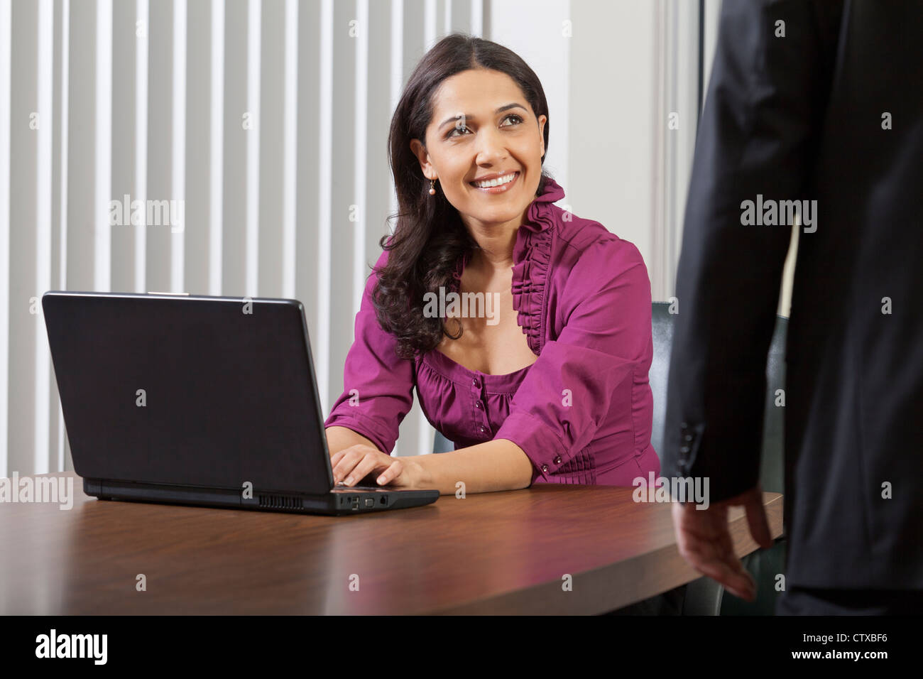 Businesswoman smiling at her boss in office Stock Photo - Alamy