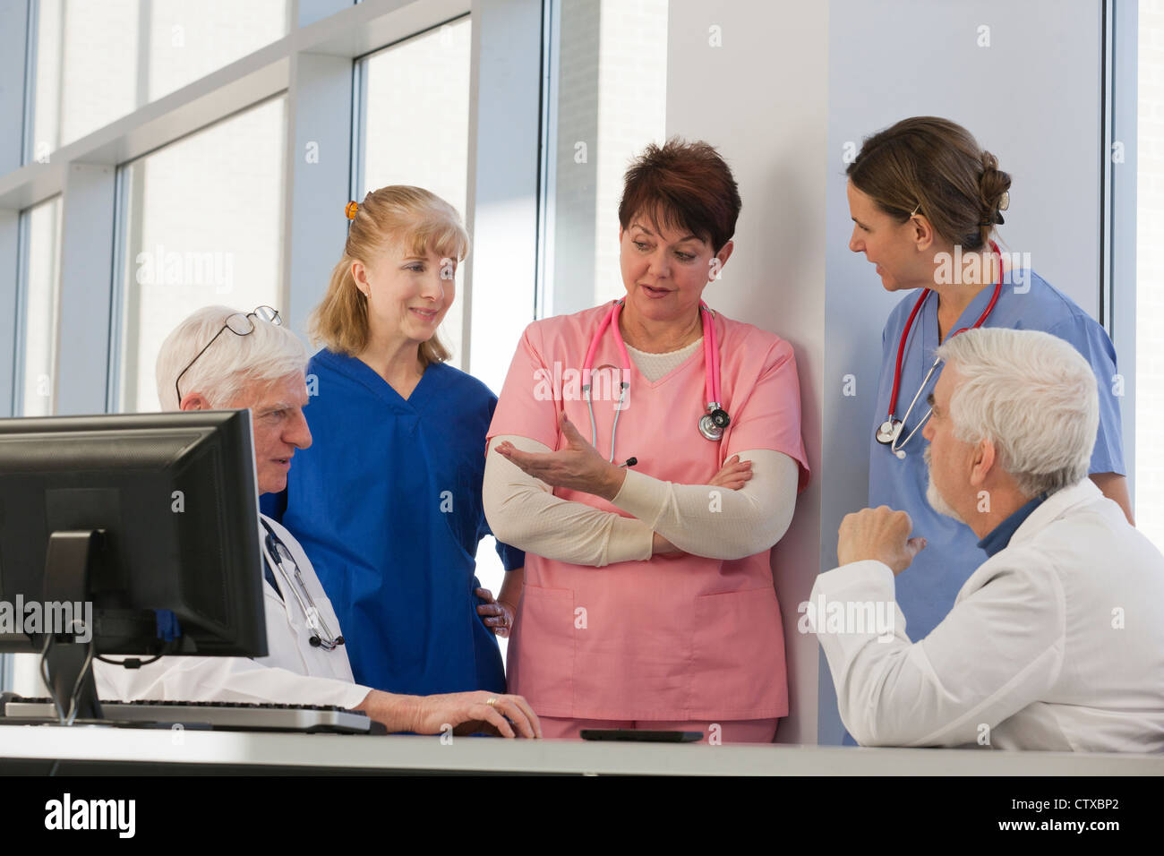 Nurses and doctors discussing patients while at computer Stock Photo ...