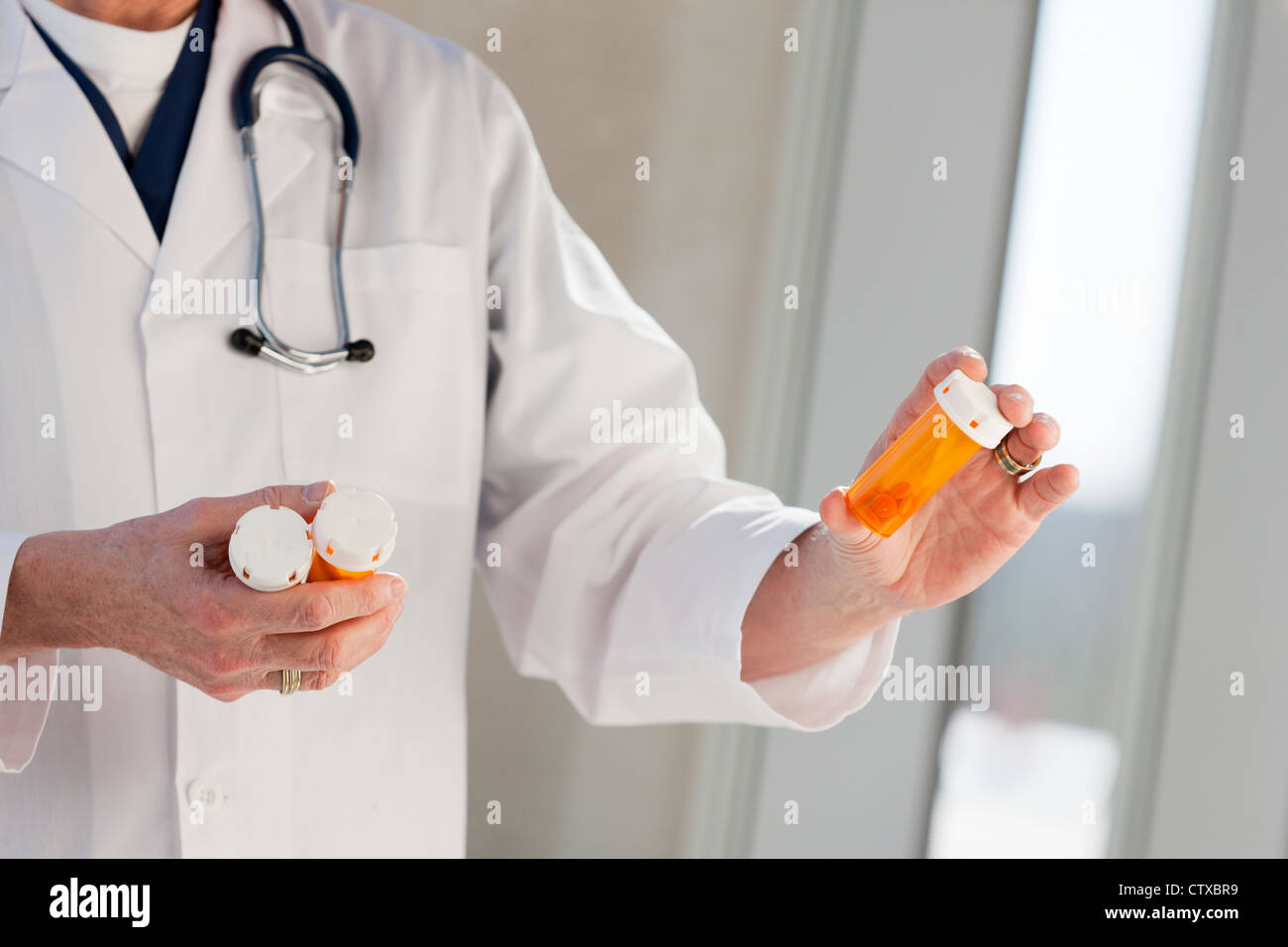 Doctor reading labels of pill bottles Stock Photo - Alamy