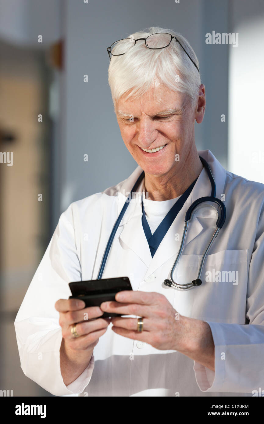 Doctor text messaging on his smartphone Stock Photo - Alamy