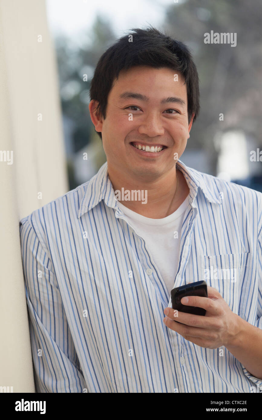 Chinese man using cell phone for text messages Stock Photo - Alamy