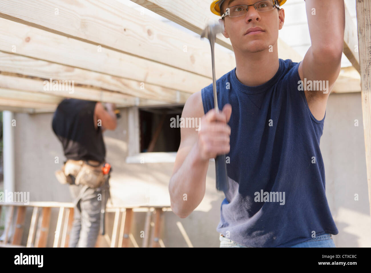 Hispanic carpenter using hammer at home deck construction Stock Photo ...