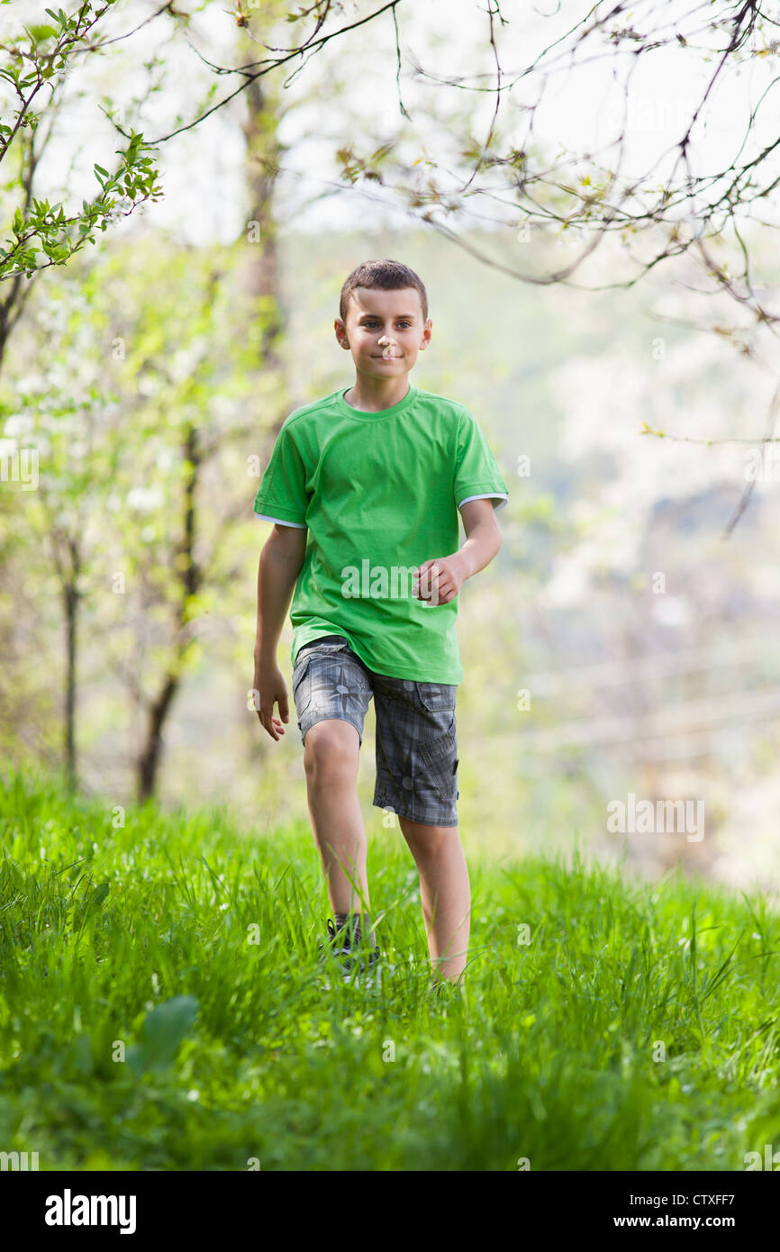 Full length portrait of a boy walking outdoor in a forest Stock Photo ...