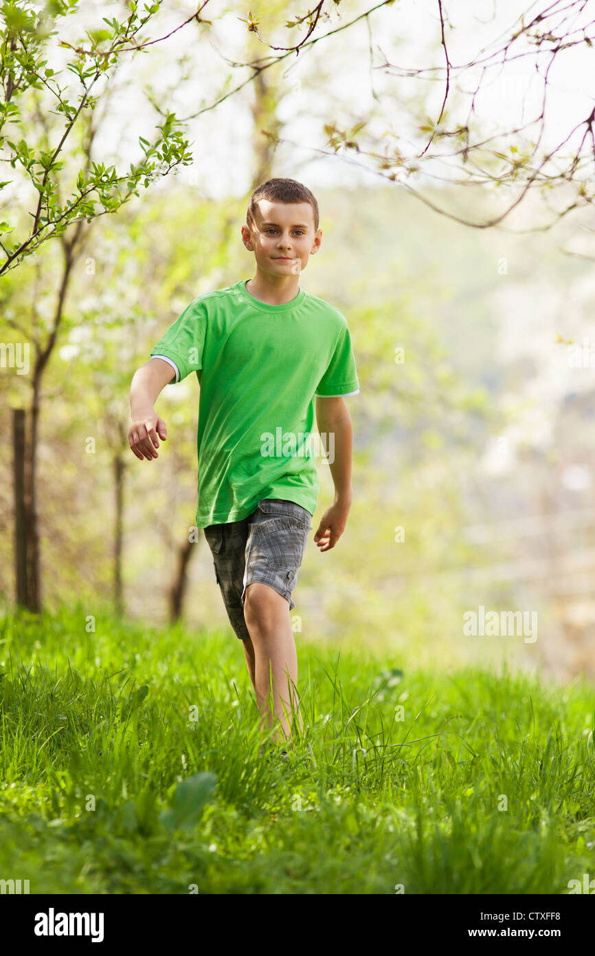 Full length portrait of a boy walking outdoor in a forest Stock Photo ...