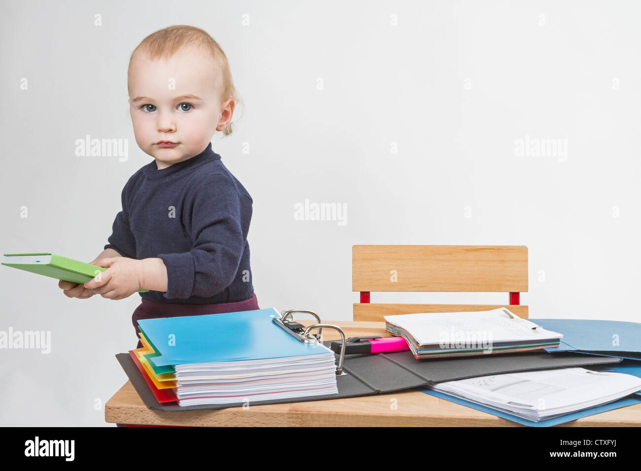 young child working at writing desk in light background Stock Photo - Alamy