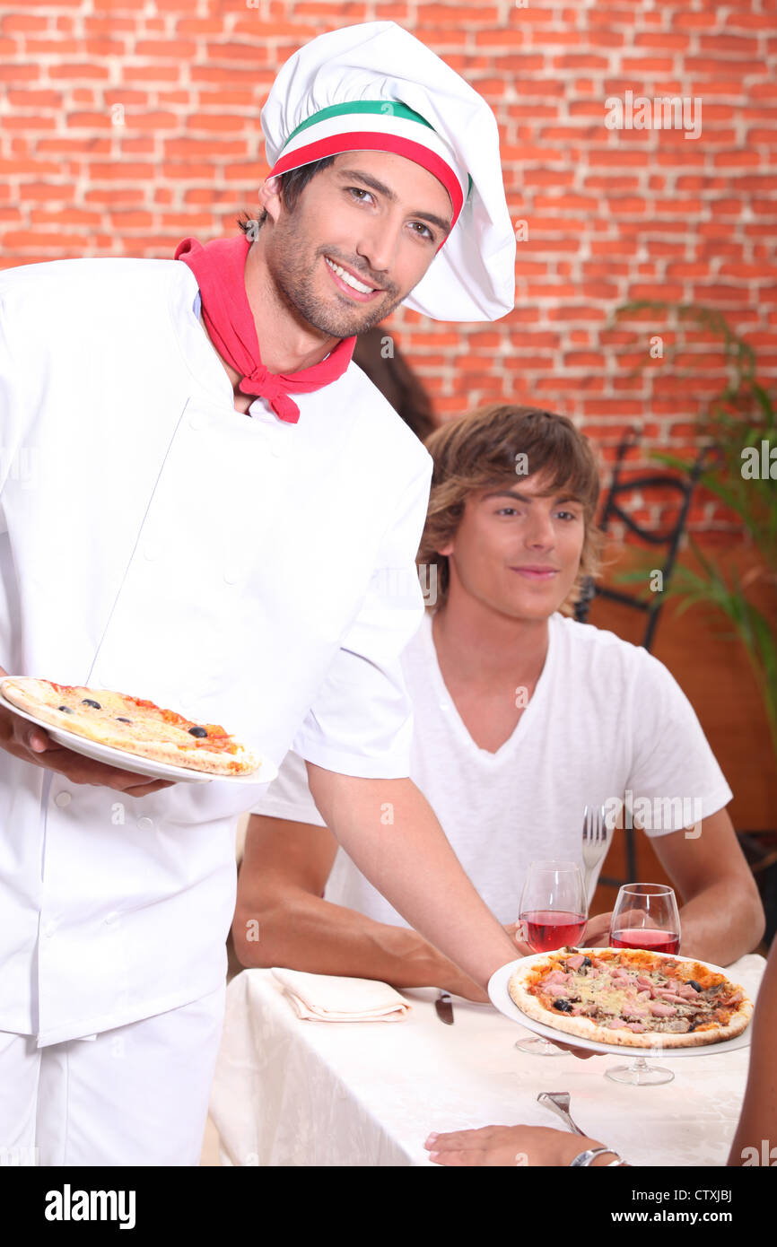 smiling pizzaiolo serving customers Stock Photo - Alamy