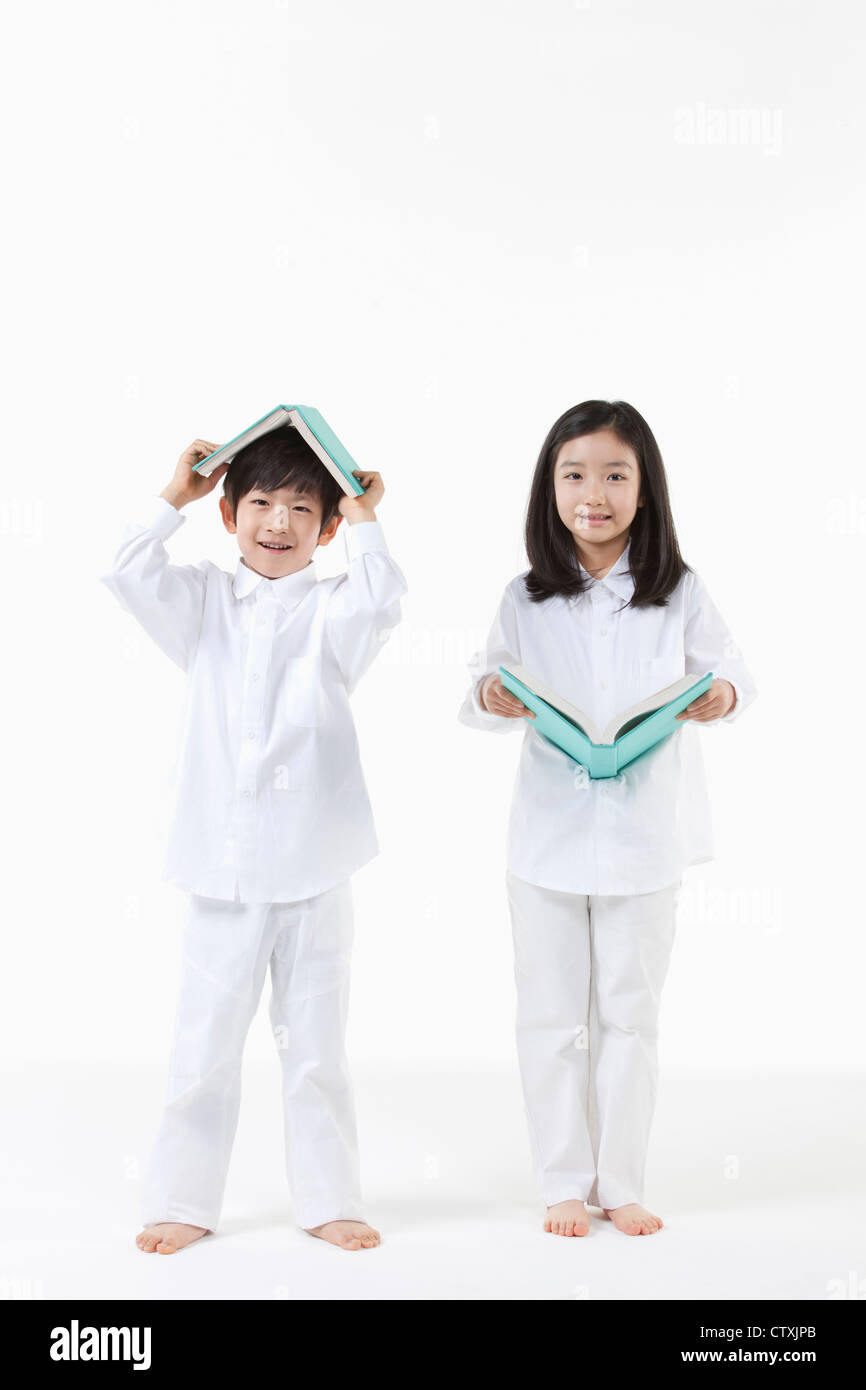 A boy and girl reading a book Stock Photo - Alamy
