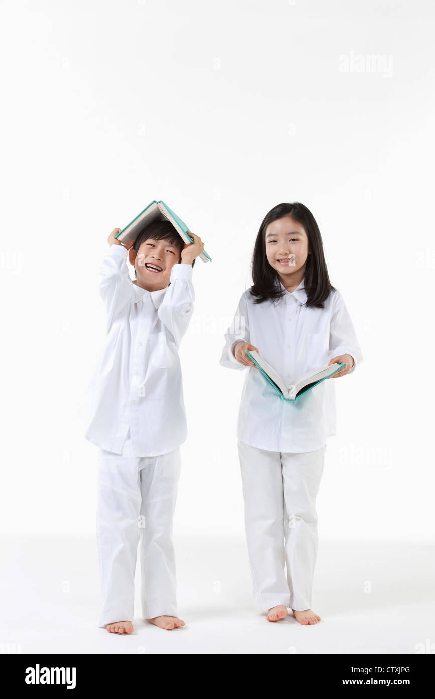 A boy and girl reading a book Stock Photo - Alamy
