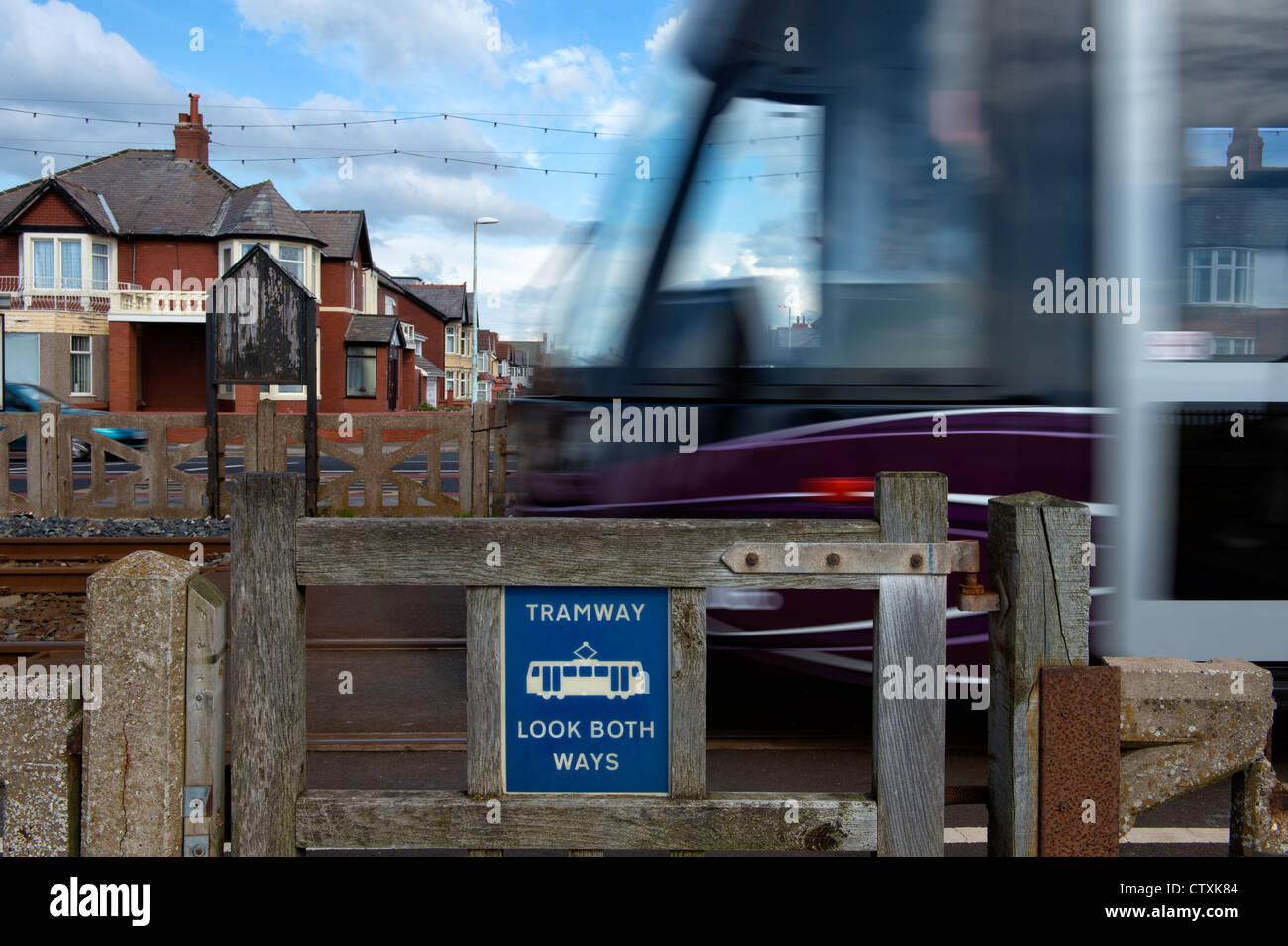 A tram speeds over a public crossing over the trams tracks in Blackpool ...