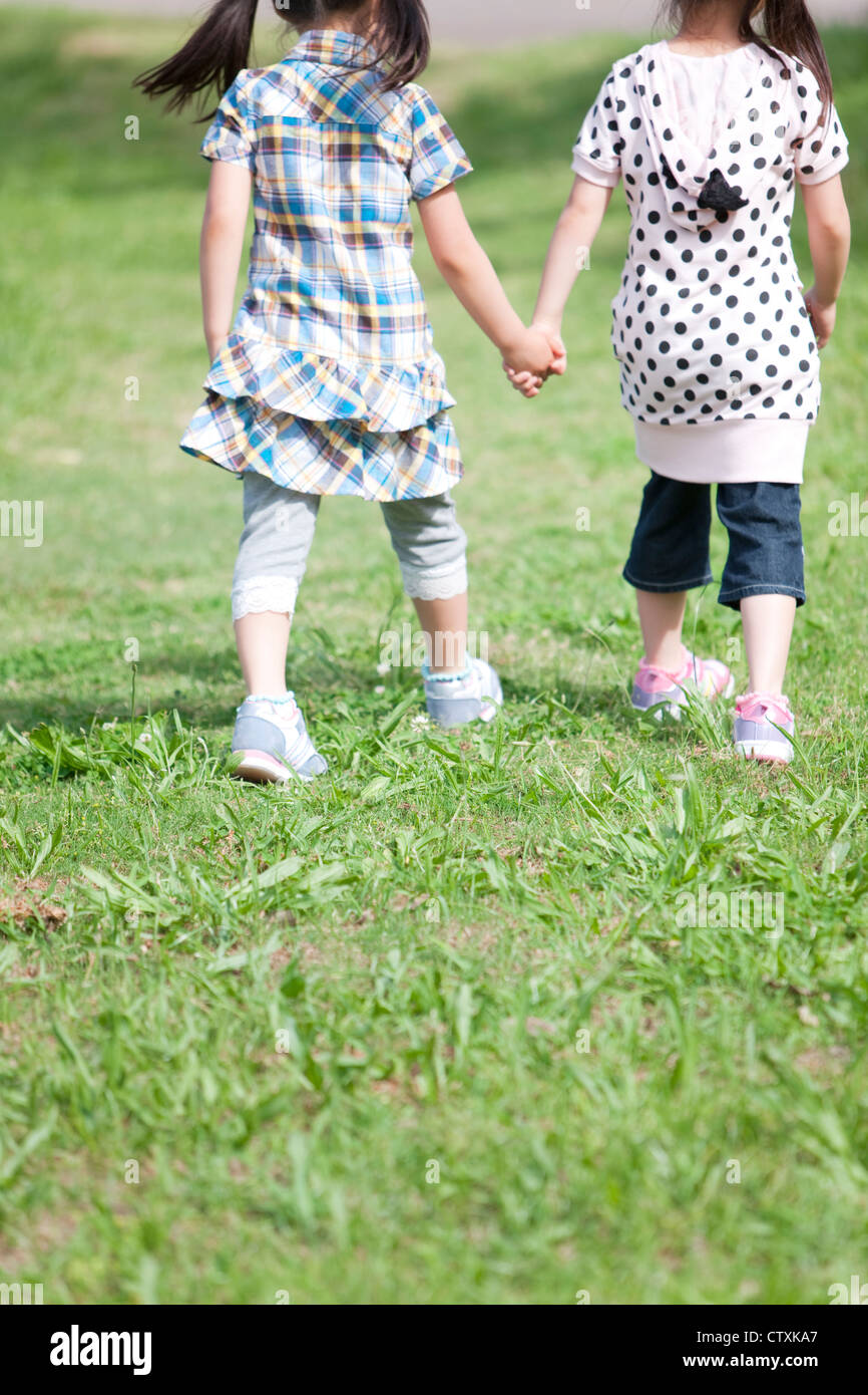 Girls holding hands Stock Photo - Alamy